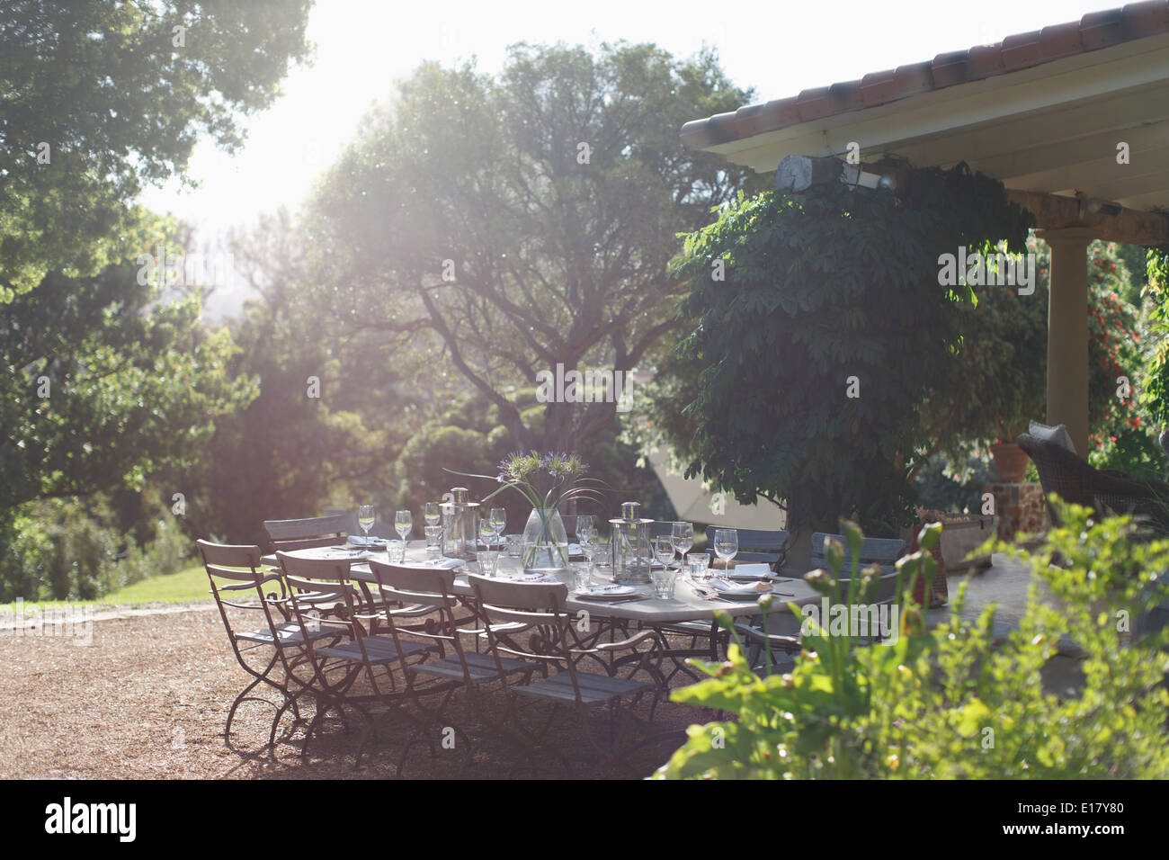 Place settings on sunny rural patio table Stock Photo - Alamy