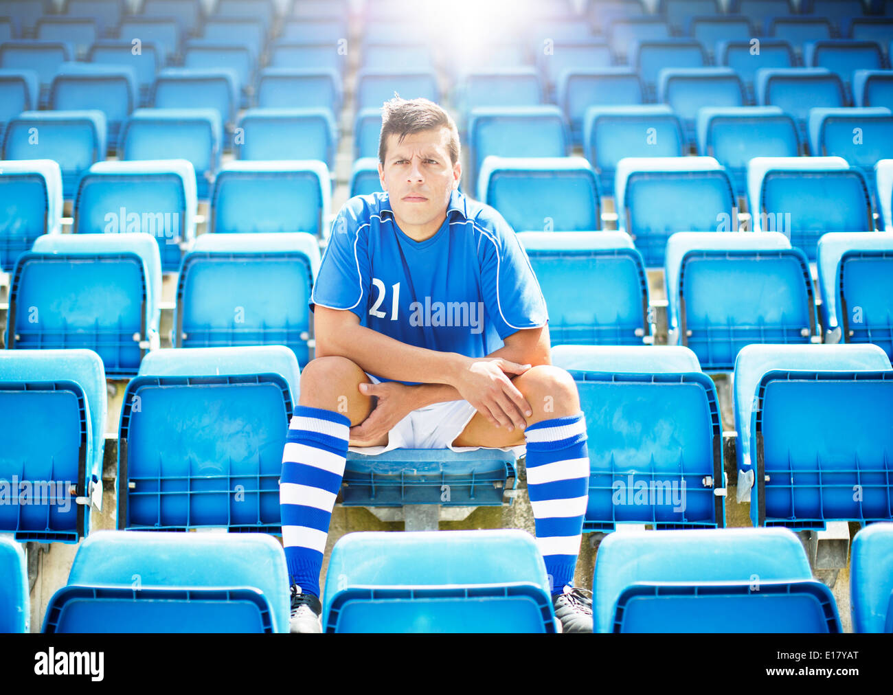 Soccer player sitting in empty stadium Stock Photo - Alamy