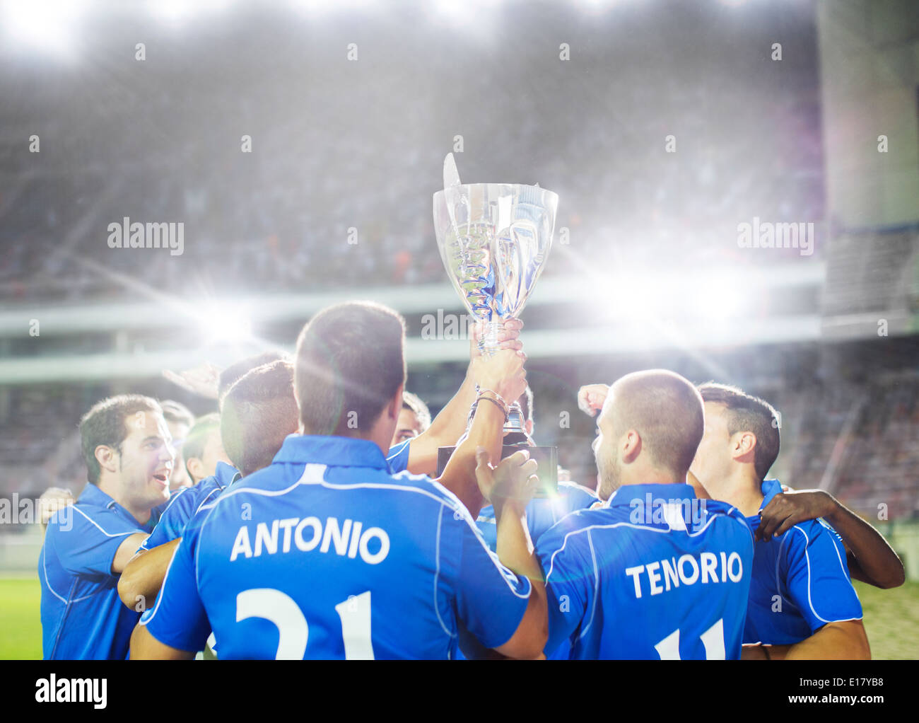 Soccer team celebrating with trophy on field Stock Photo - Alamy