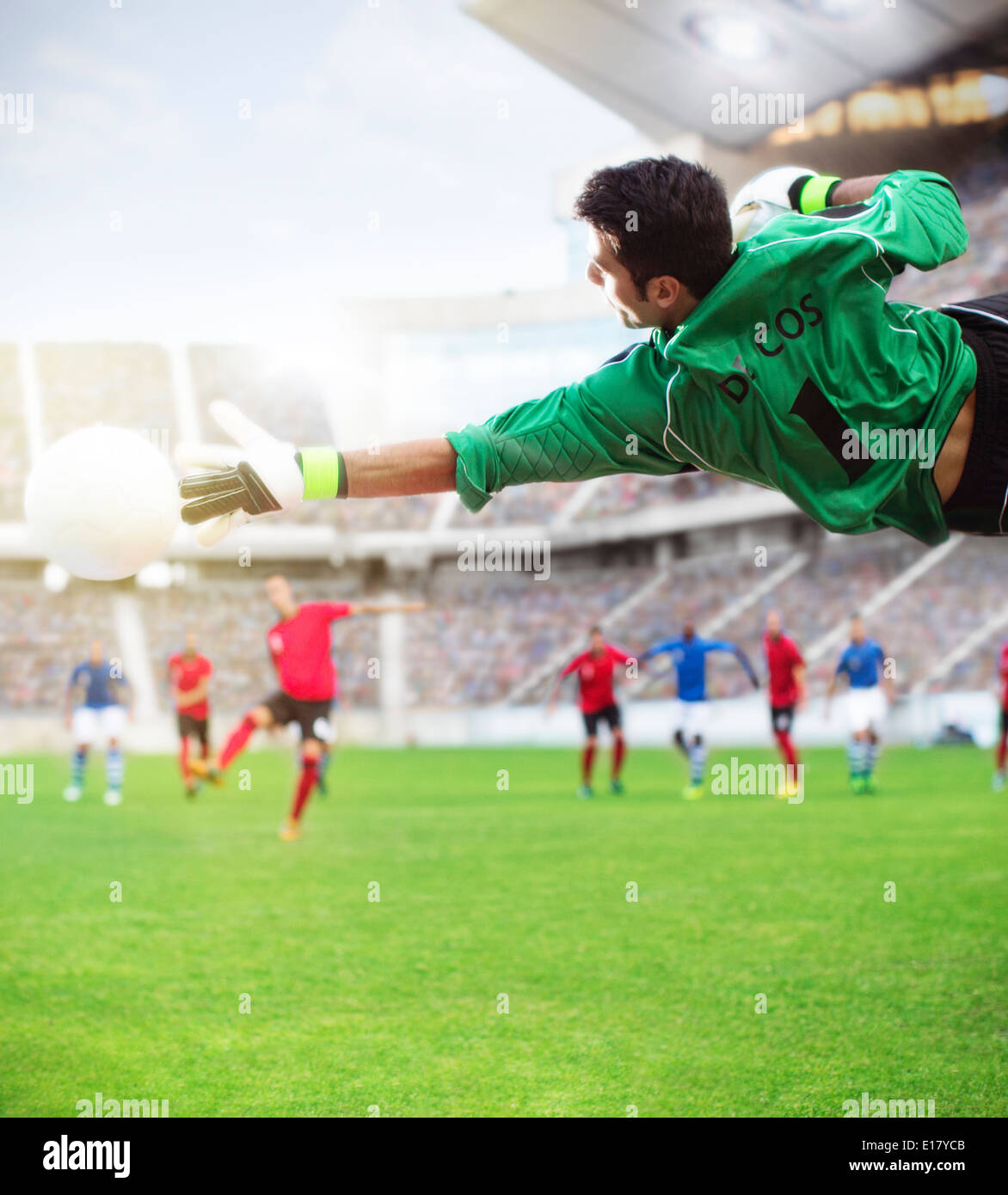 Goalie reaching for ball in mid-air on soccer field Stock Photo - Alamy