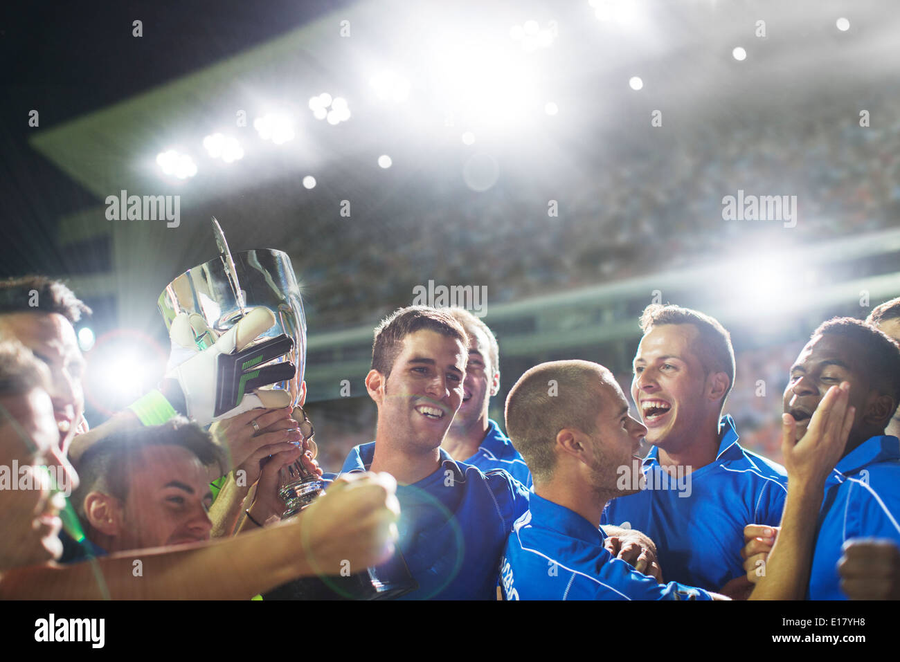 Soccer team celebrating with trophy on field Stock Photo - Alamy