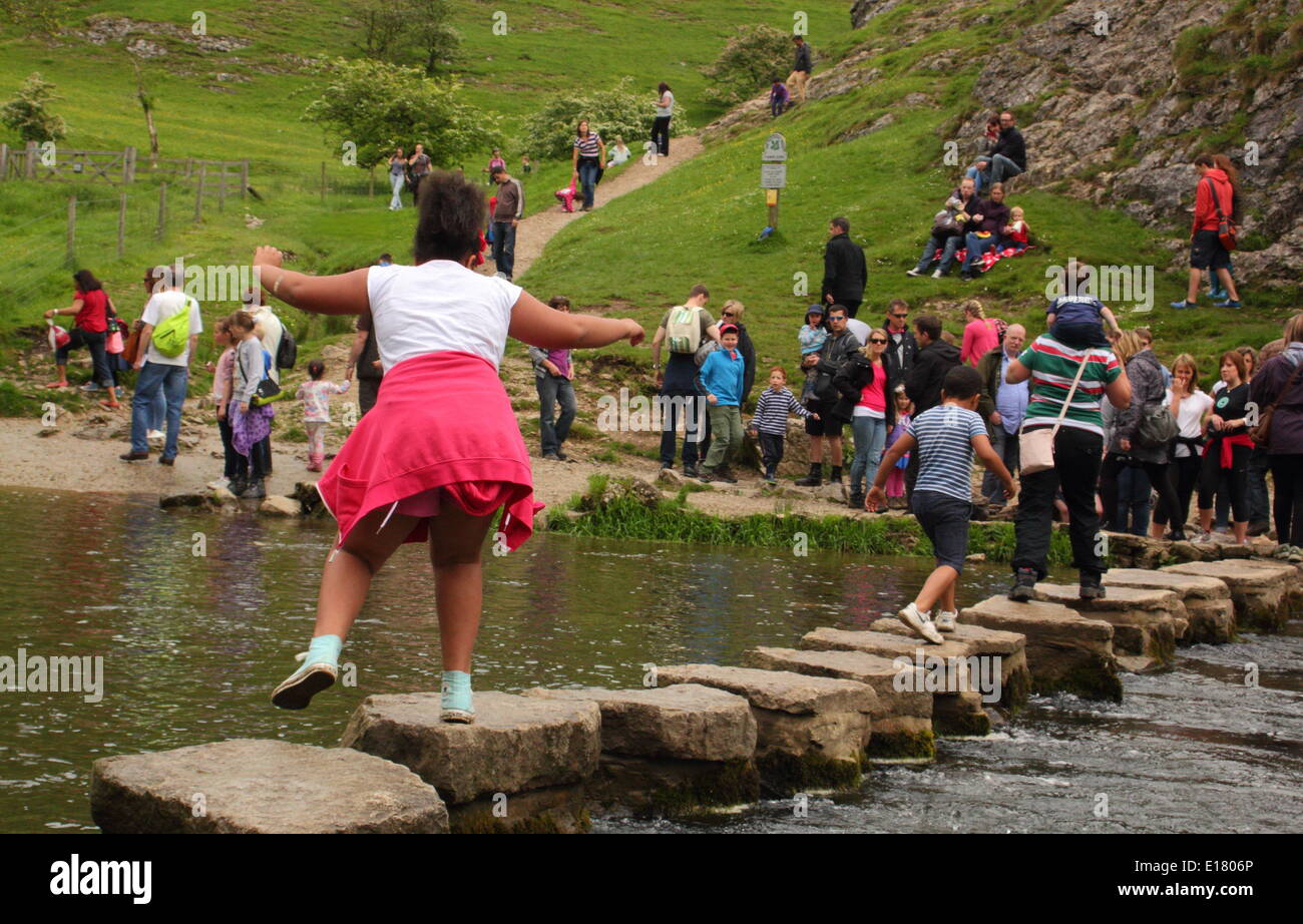 A family crosses the stepping stones of the River Dove at Dovedale in ...