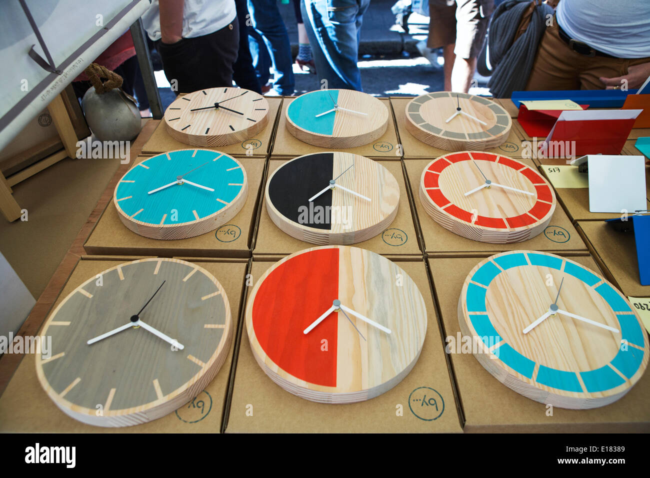 Wooden clocks on display on a market stall in a street market in London ...