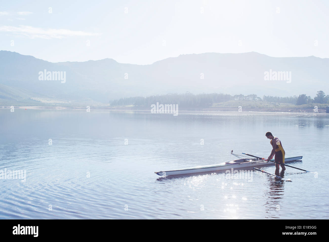 Man placing rowing scull in lake Stock Photo - Alamy