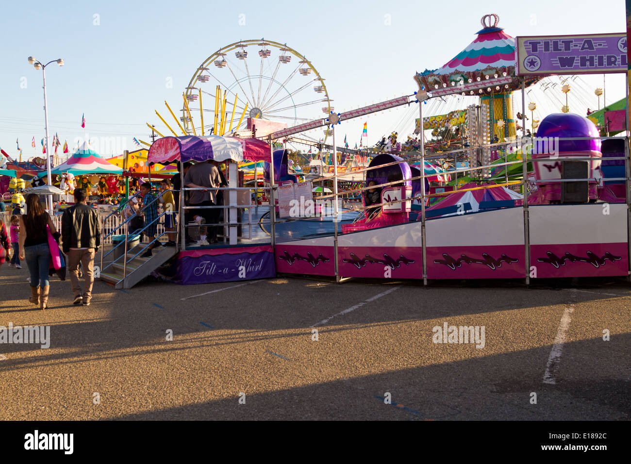 Carnival scene in late afternoon showing crowd and rides Stock Photo ...