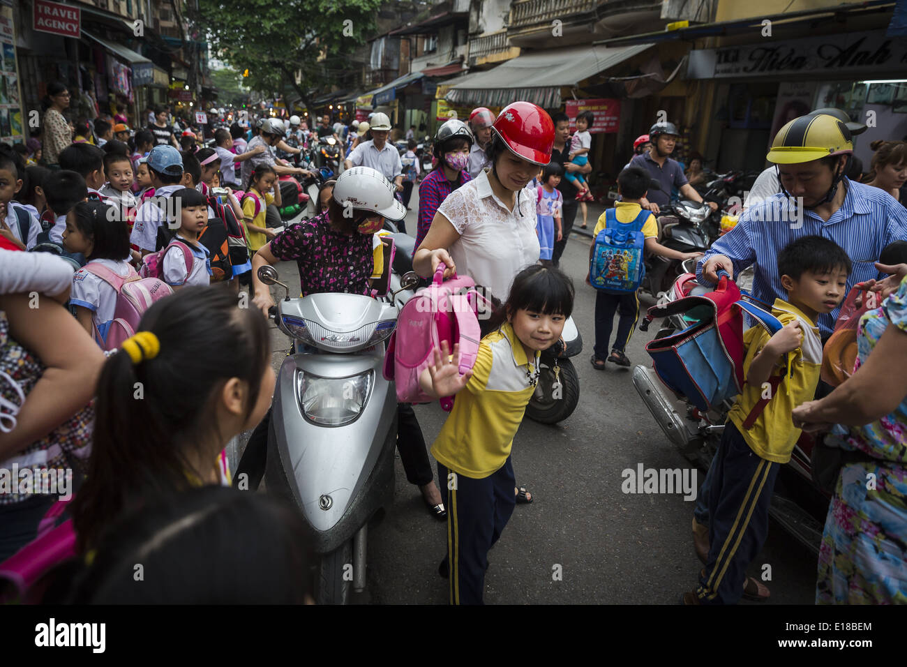 A group of parents come to pick up their children at the exit of one of ...