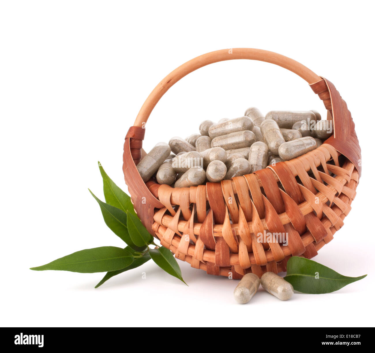 Herbal drug capsules in wicker basket isolated on white background ...