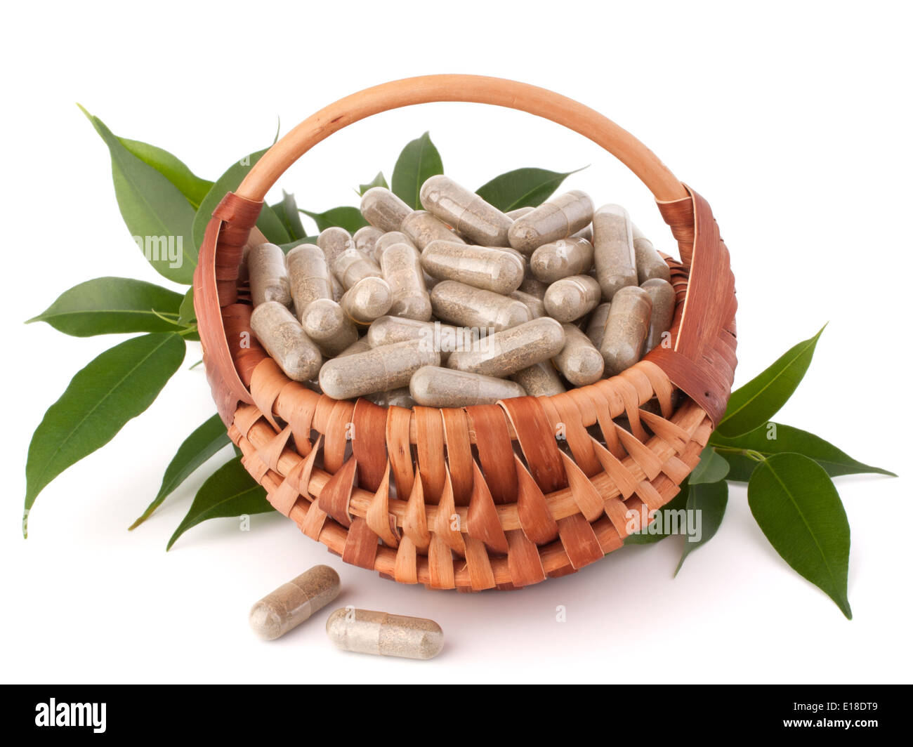 Herbal drug capsules in wicker basket isolated on white background ...