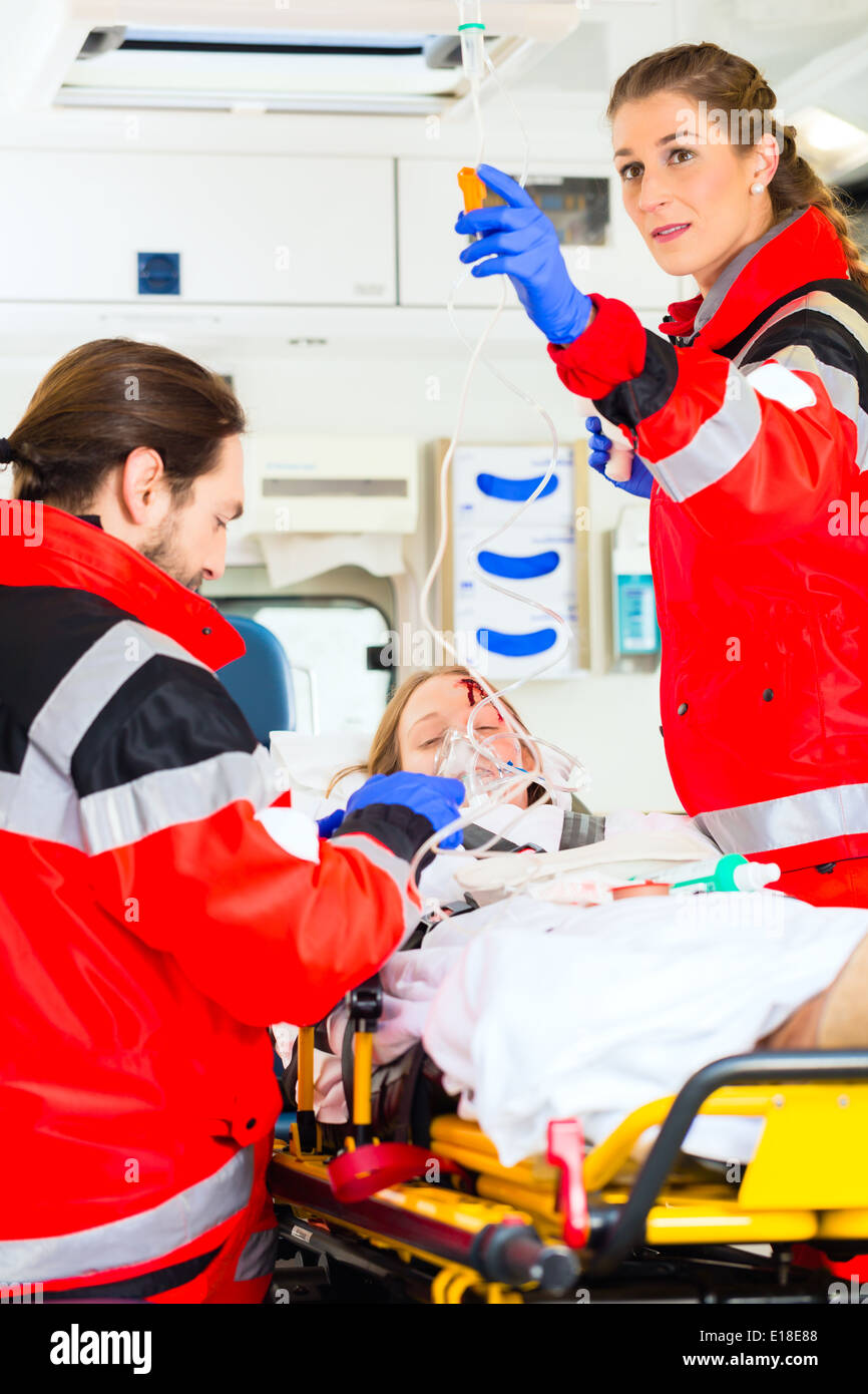 Emergency doctor and nurse or ambulance team medicate accident victim ...