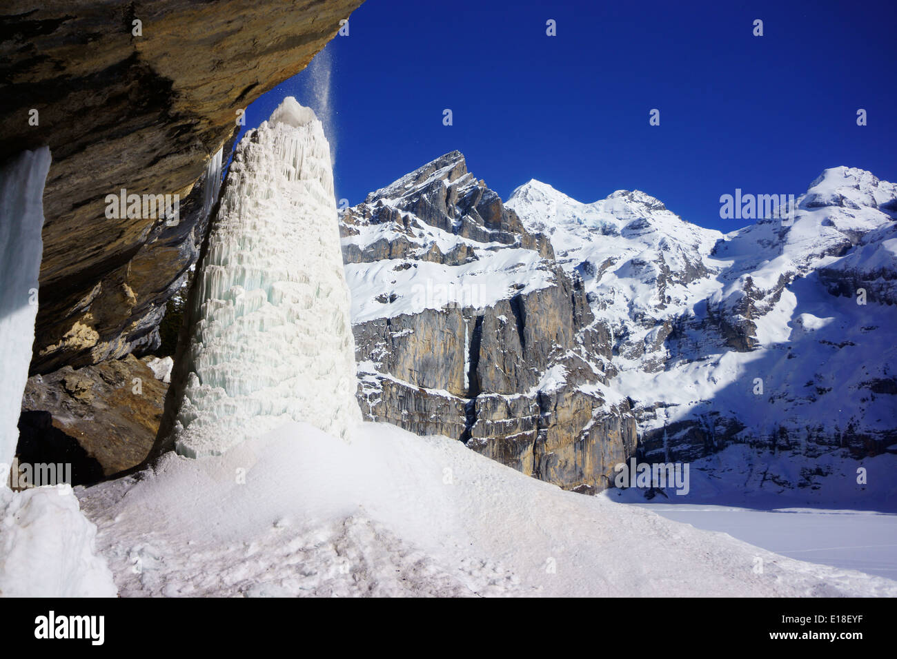 Ice pillar under Waterfall at Oeschinen Lake, Bluemlisalphorn in back ...