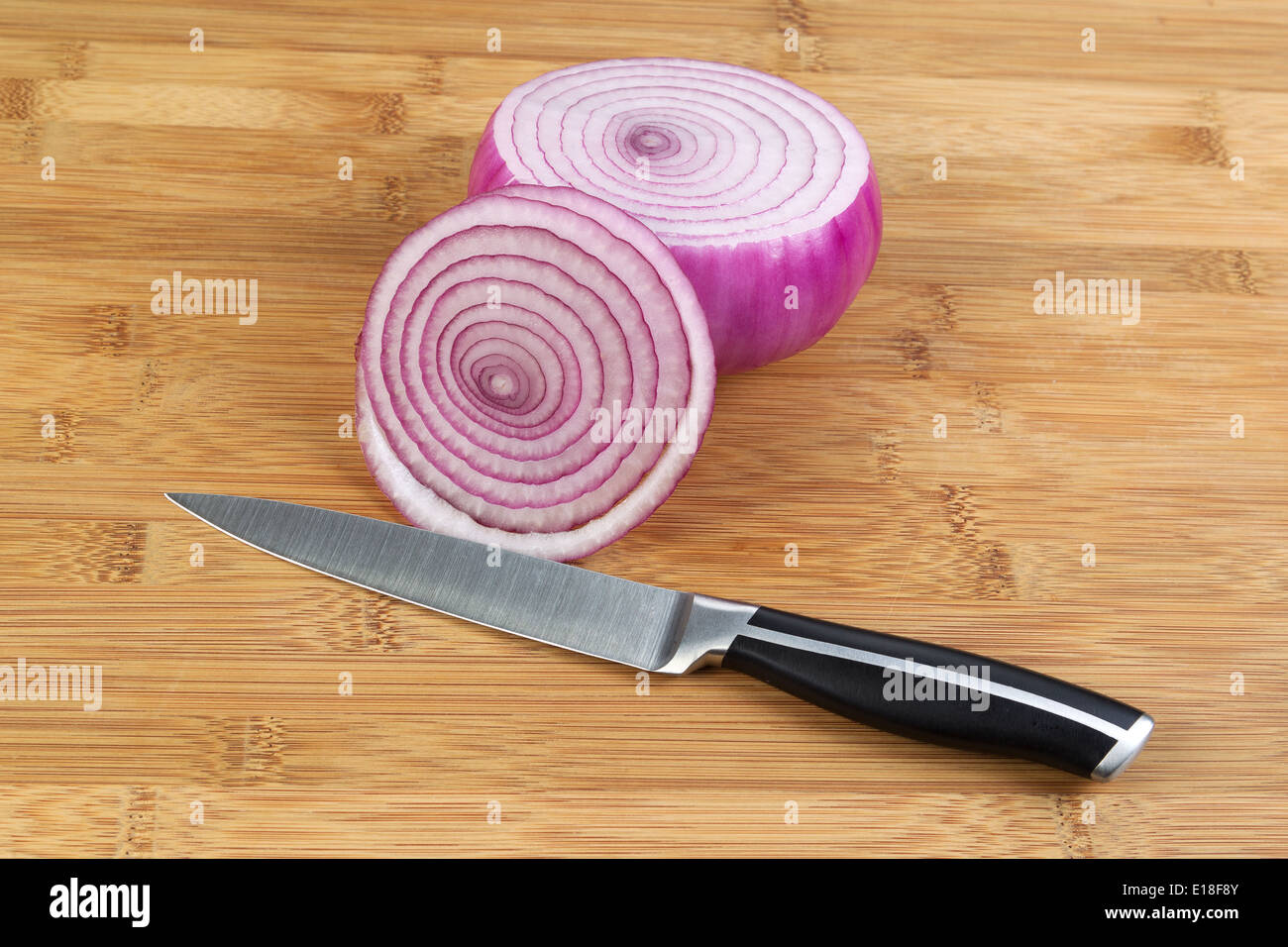 Closeup horizontal photo of freshly sliced red onion with kitchen knife ...