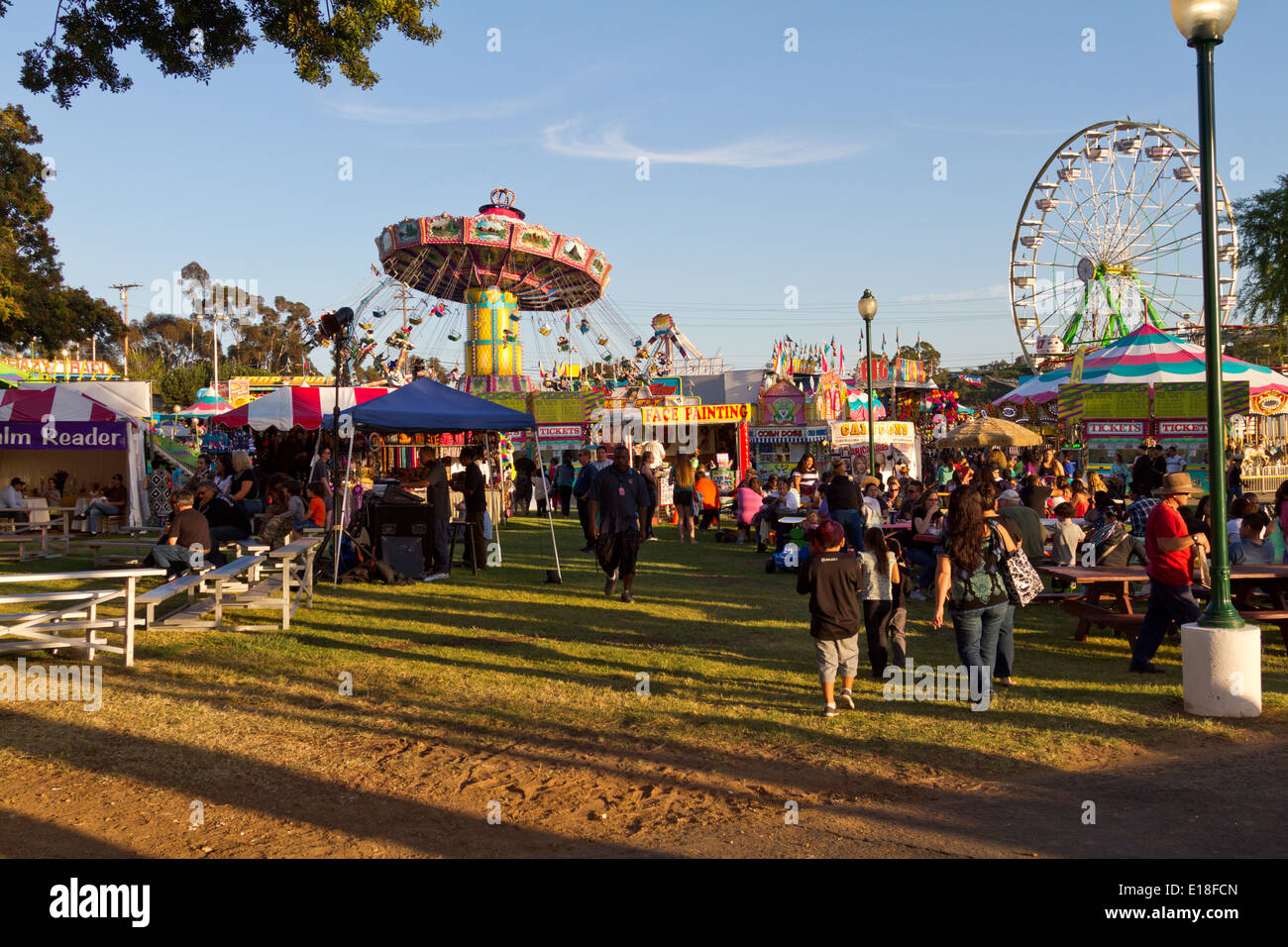 Carnival scene in late afternoon showing crowd and rides Stock Photo ...