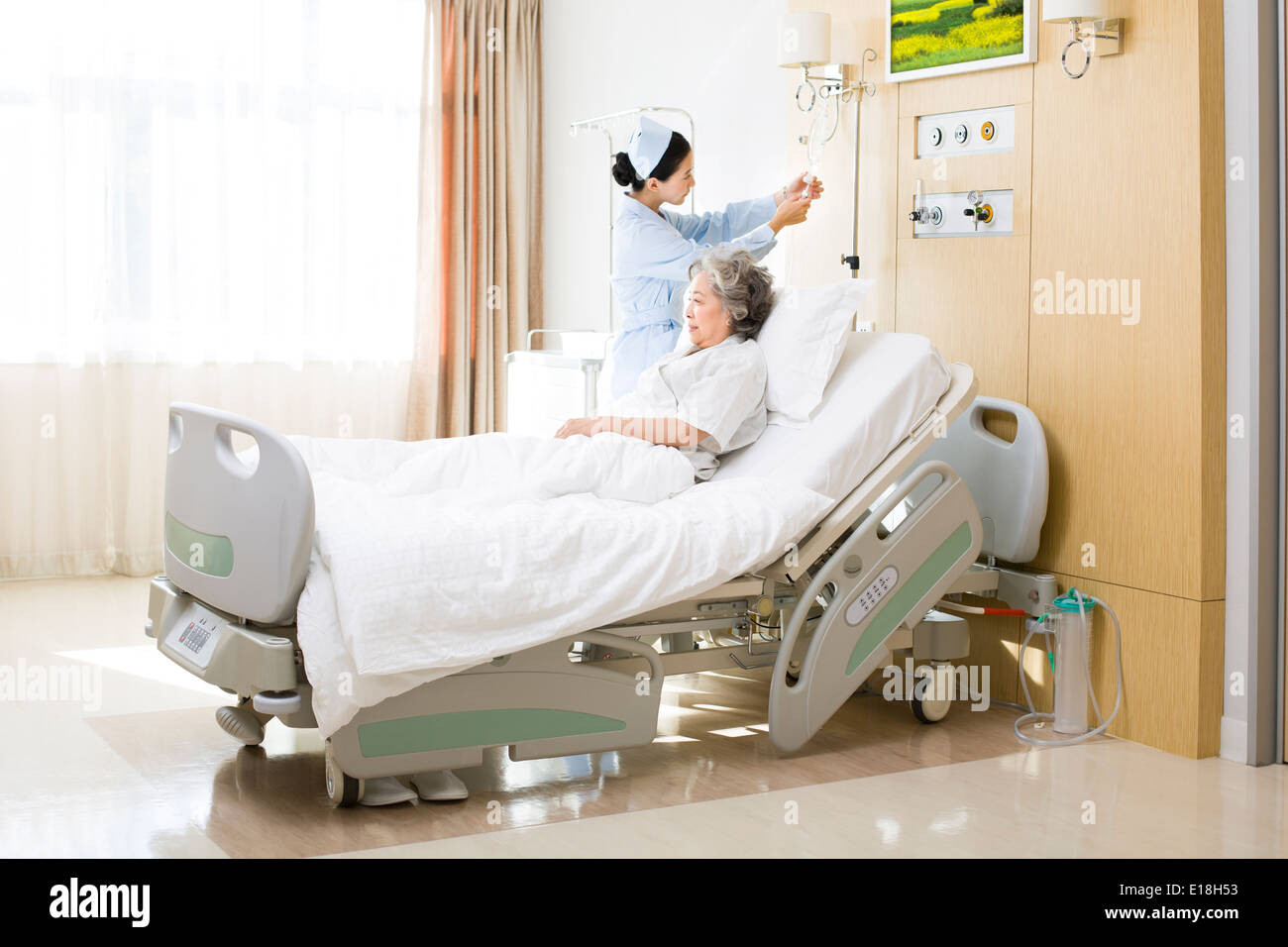 Nurse helping patient changing IV drop Stock Photo - Alamy