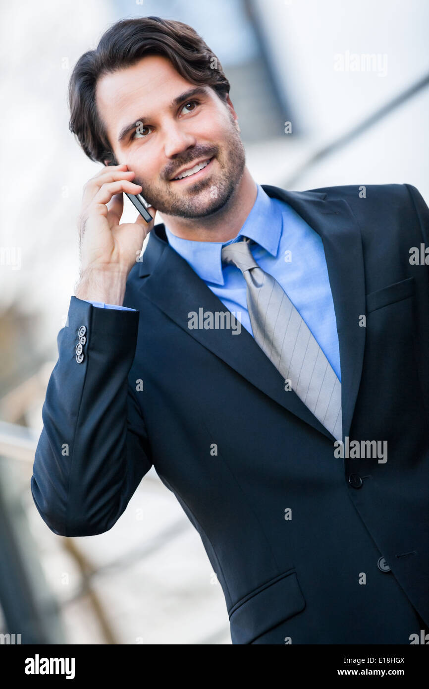Businessman listening to a call on his mobile Stock Photo - Alamy