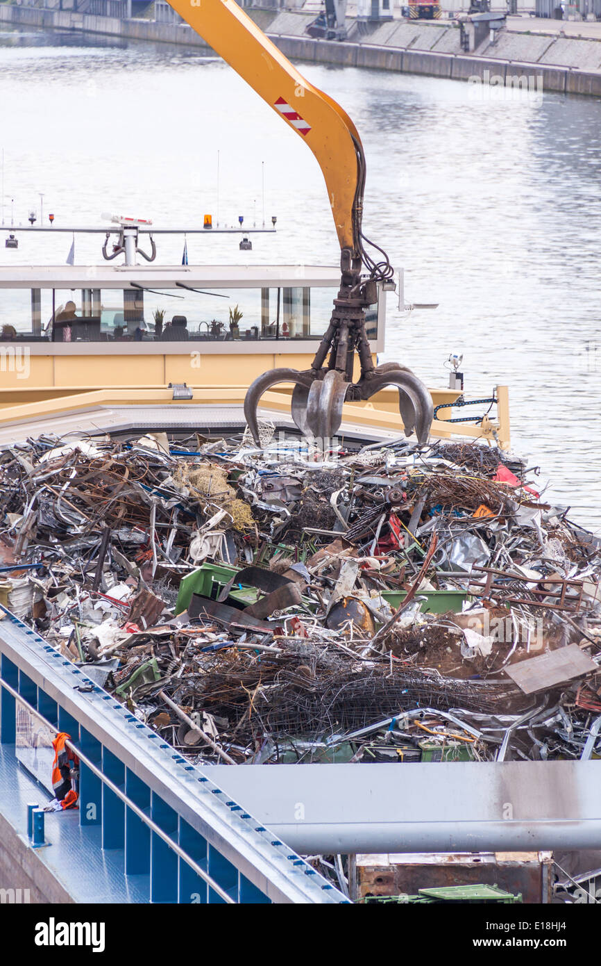 Open barge being loaded or offloaded at a wharf on an urban waterway or ...