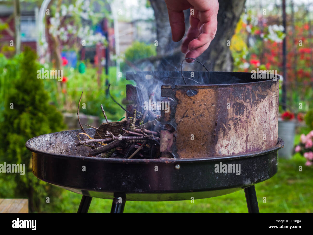 Lighting the fire during the spring barbecue in the garden Stock Photo ...