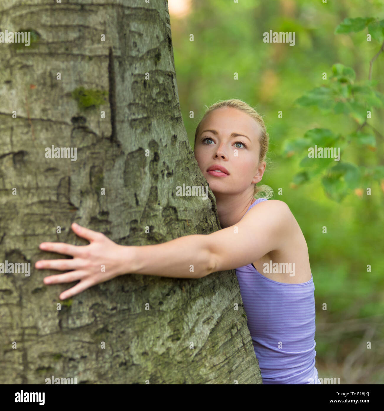 Young woman hugging a tree Stock Photo - Alamy