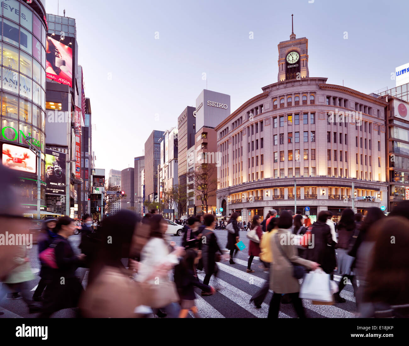 People crossing street in front of Wako Department Store building in ...