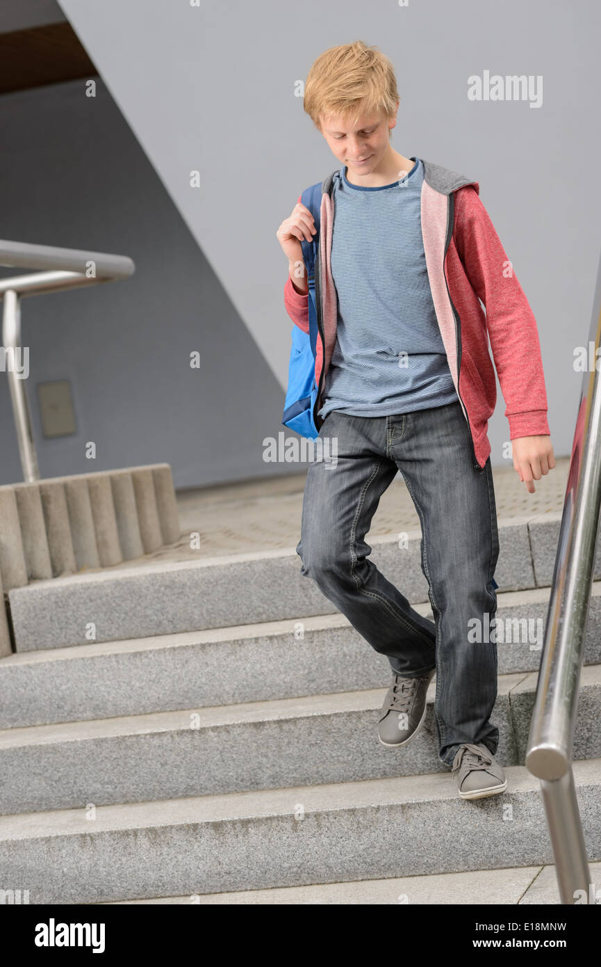 Full length of teenage student walking down university stairs Stock ...