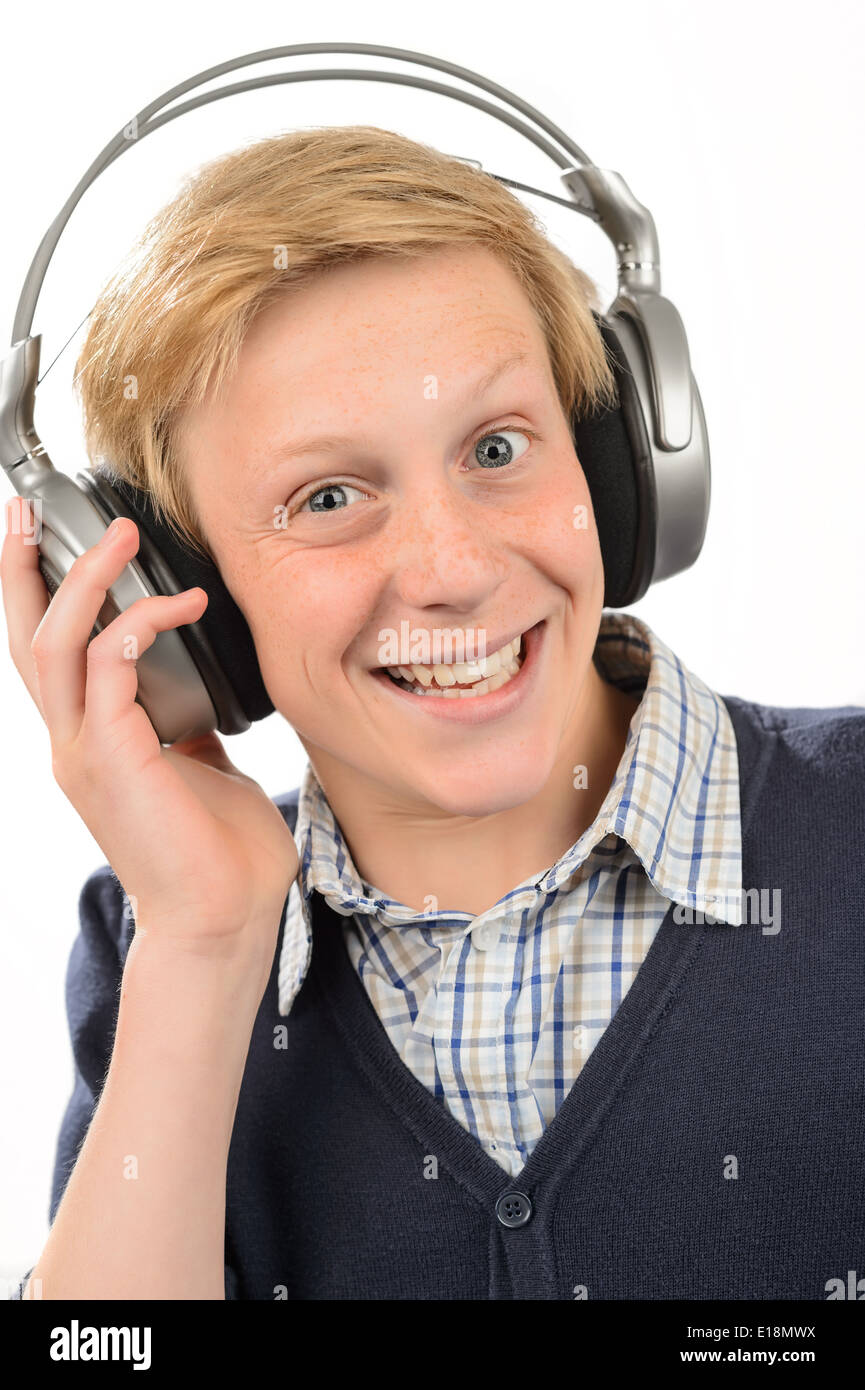 Cheerful teenage boy listening to music through headphones white ... Cheerful teenage boy listening to music through headphones white ...
