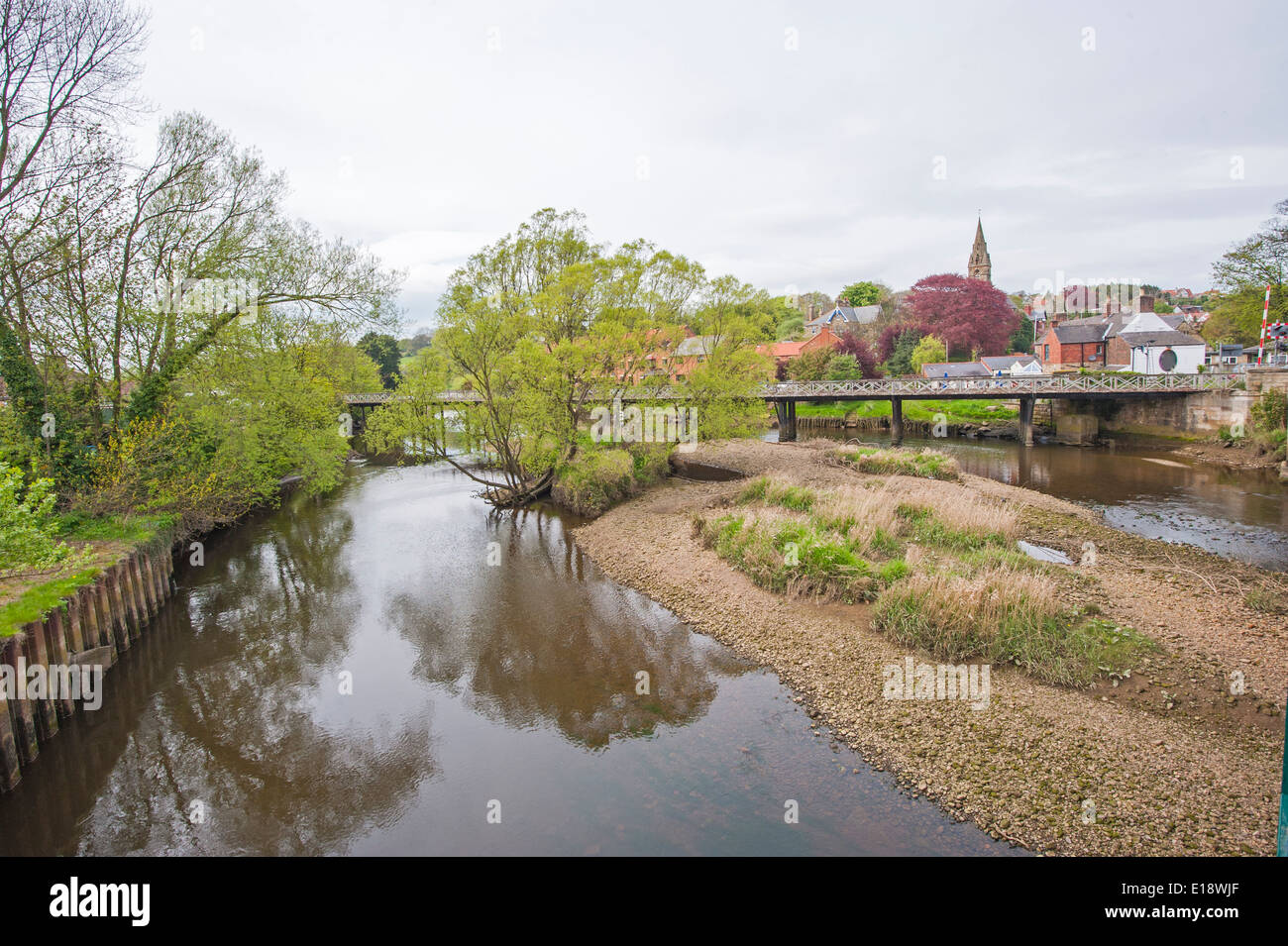 English rural countryside scene of view down river with railway bridge ...