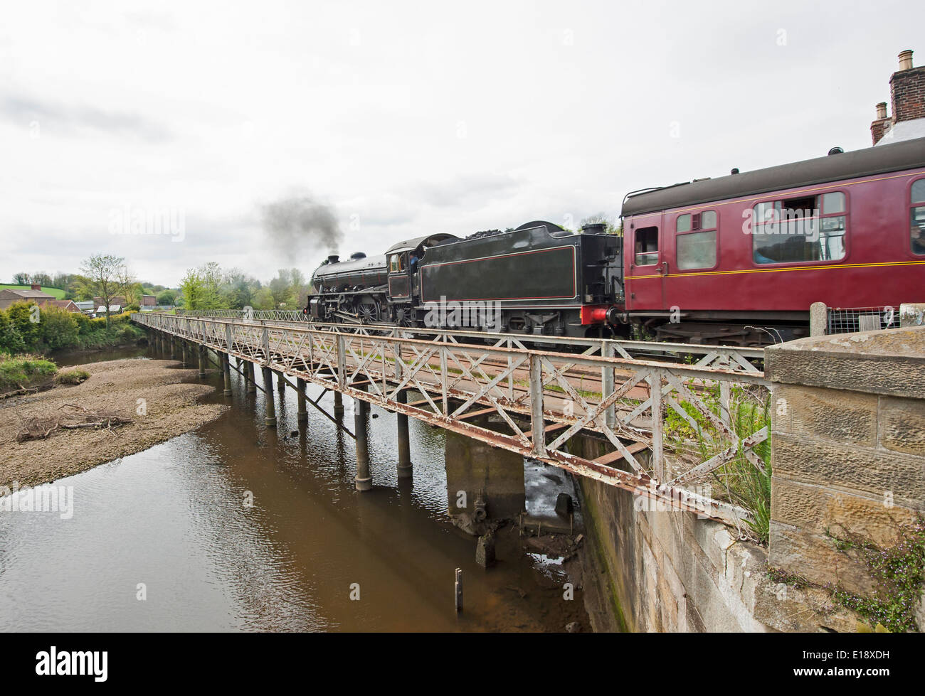 Traditional steam train in english rural countryside travelling on ...