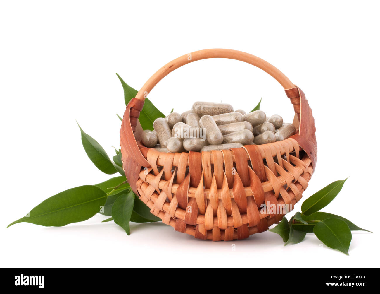 Herbal drug capsules in wicker basket isolated on white background ...