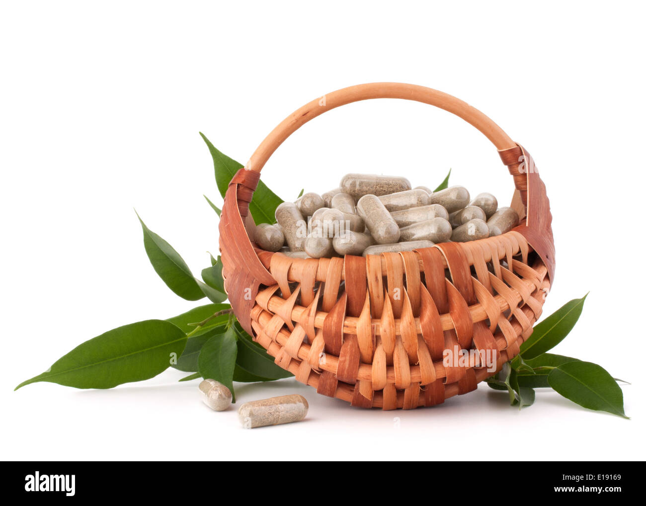 Herbal drug capsules in wicker basket isolated on white background ...