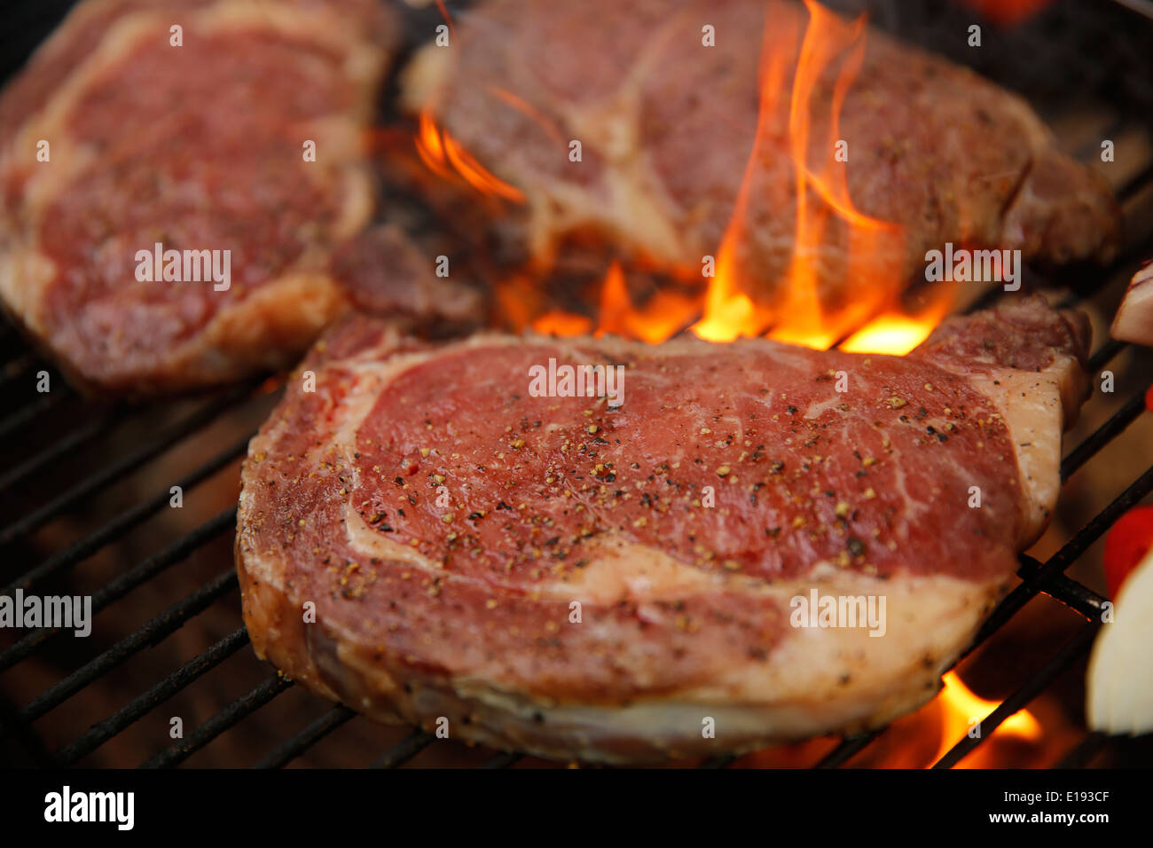 food cooking grilling flames bbq ribeye steaks grill Stock Photo - Alamy
