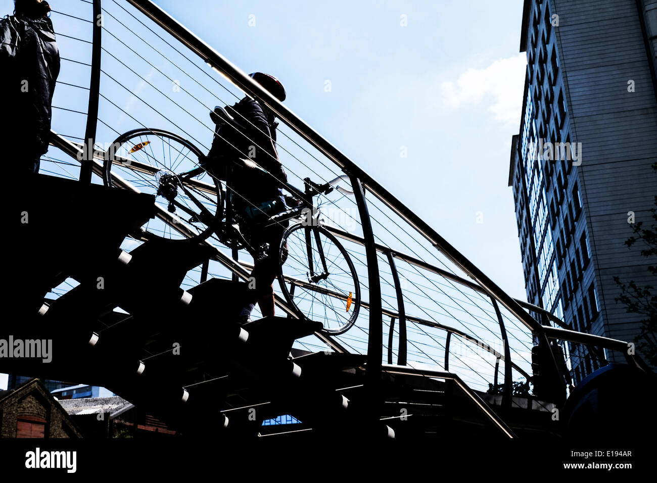 A cyclist carrying his bicycle down steps Stock Photo - Alamy