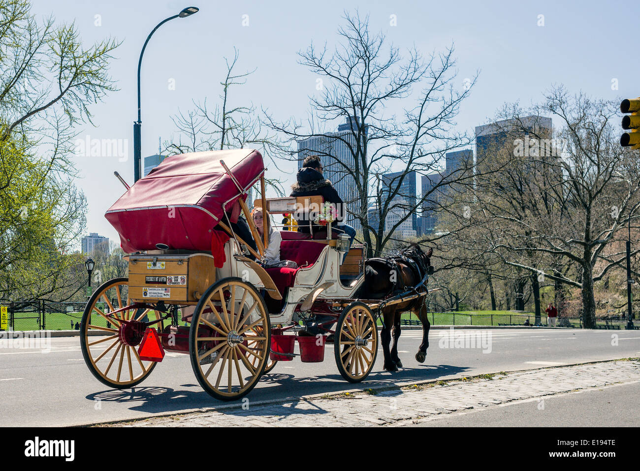Tourists ride a horse carriage tour through New York's Central Park in ...