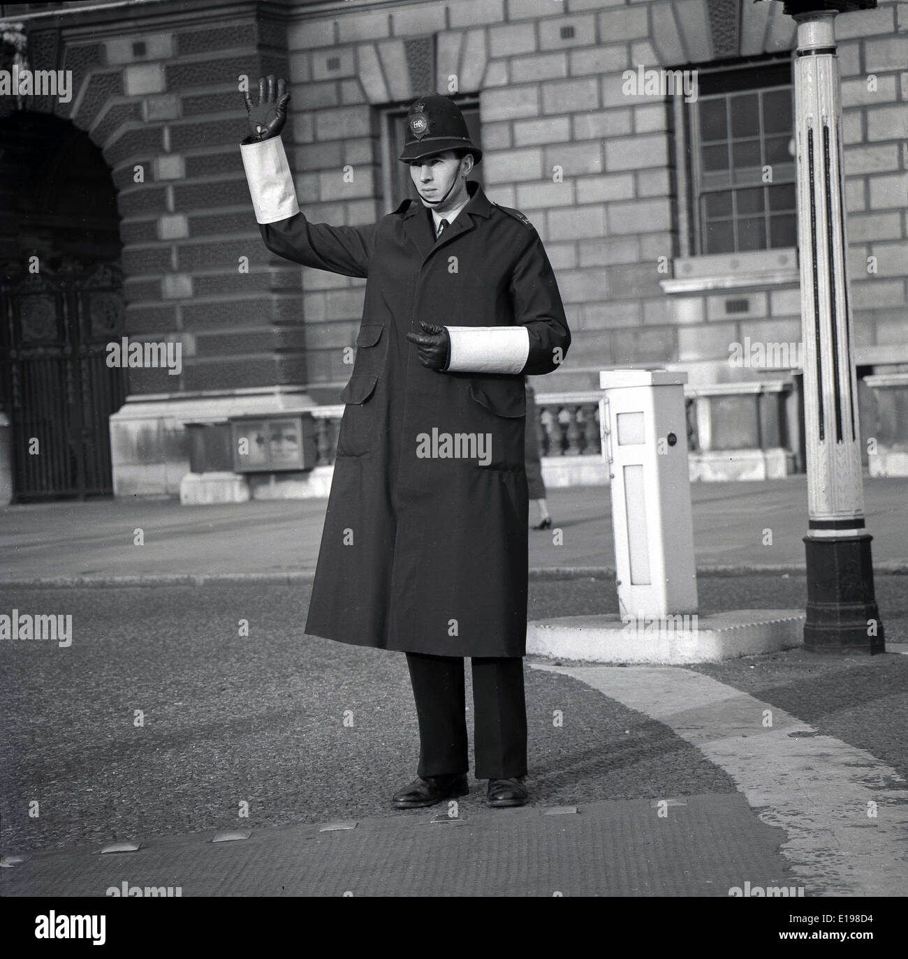 1960s. Historical picture of a British policeman wearing helmet, cape ...
