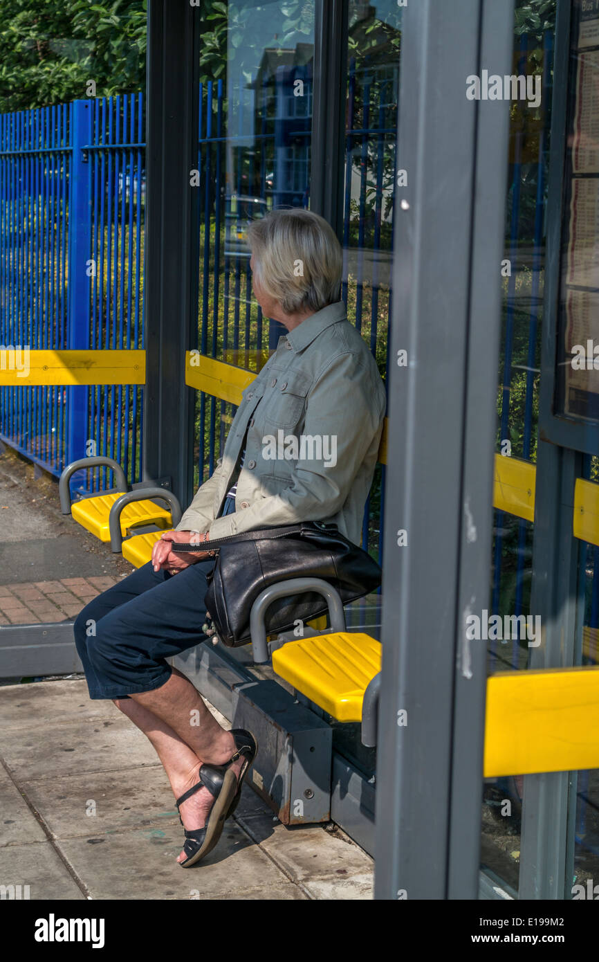 Lady waiting at the bus stop waiting for the bus Stock Photo - Alamy