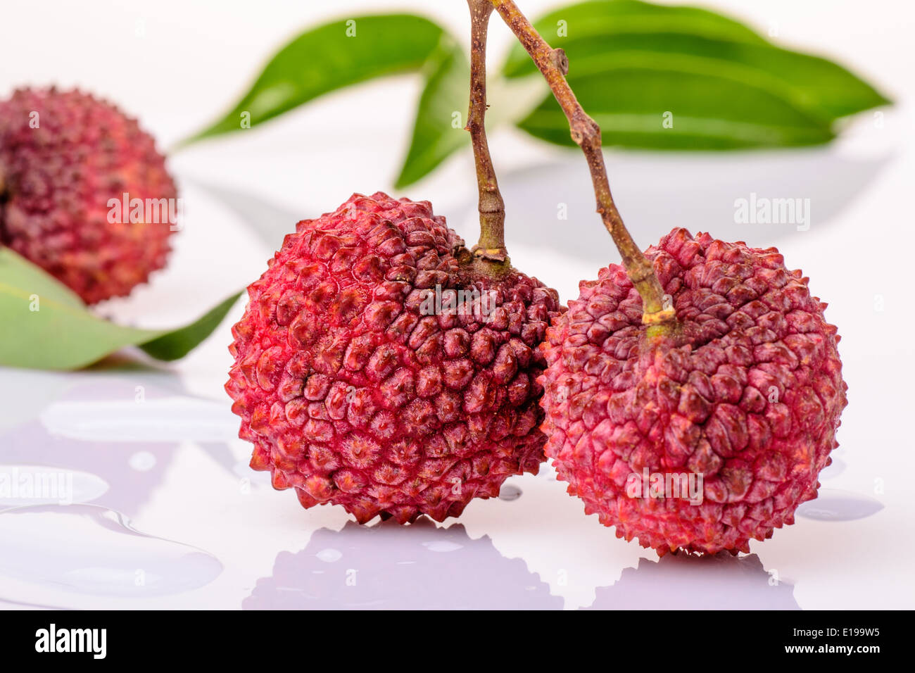 fresh lychee with green leaves on the white background Stock Photo - Alamy