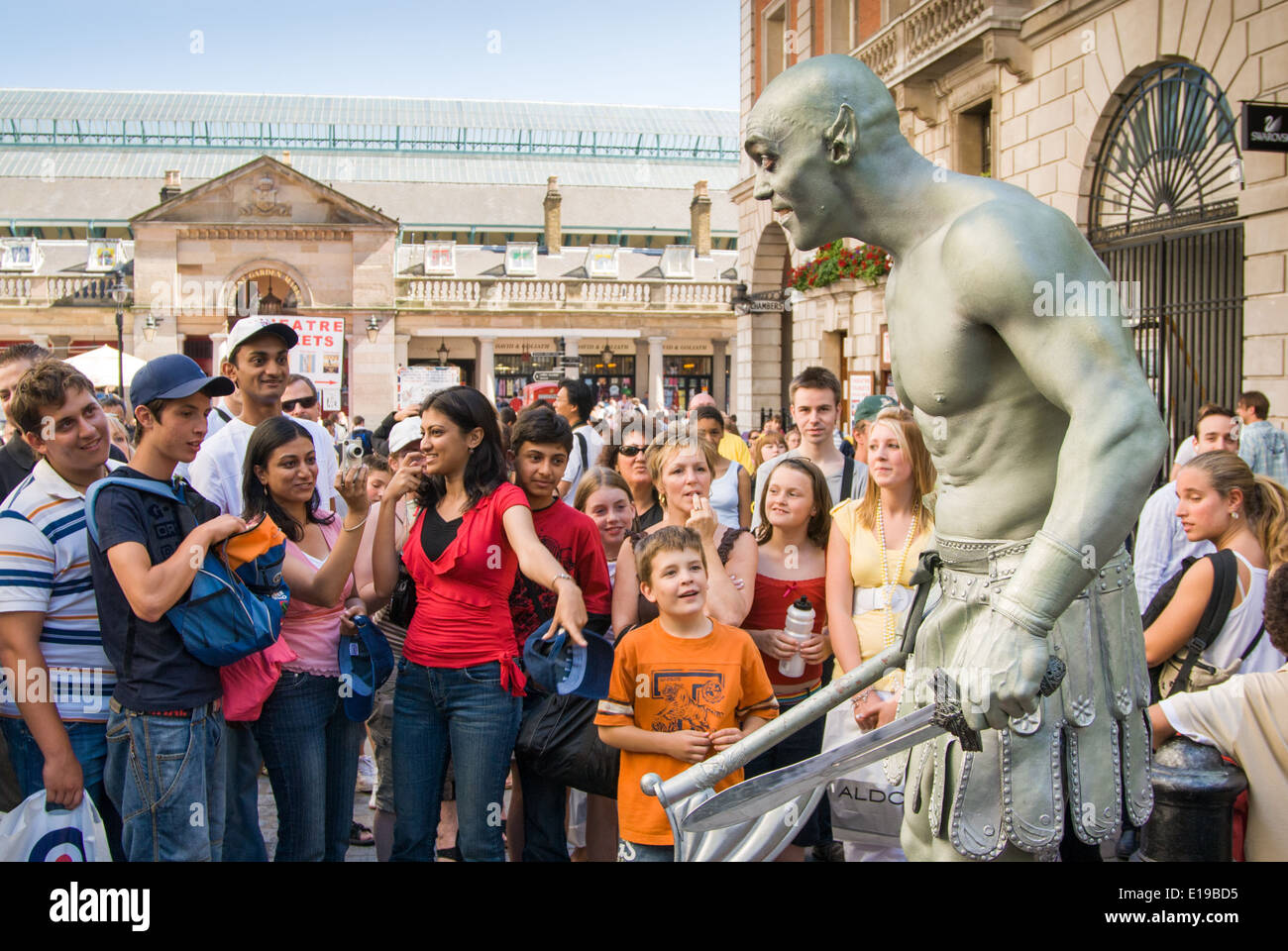 Mime artist Duncan Meadows as a giant green human statue performing for ...