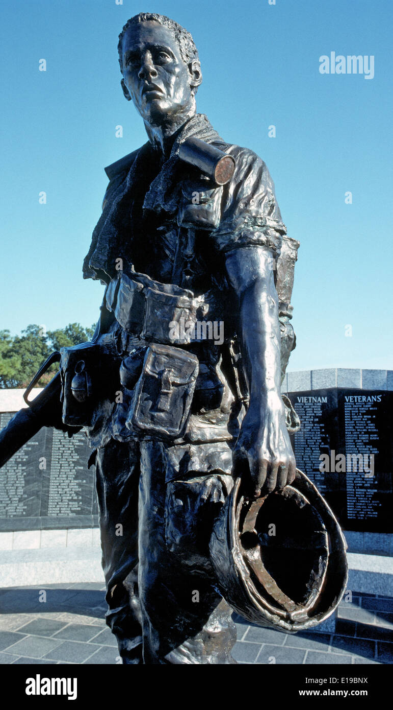 A bronze statue of a saddened soldier holding his helmet and rifle is ...