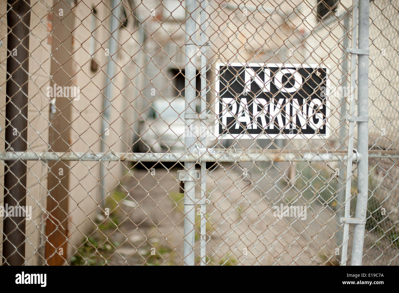 No parking sign behind chainlink fence Stock Photo - Alamy