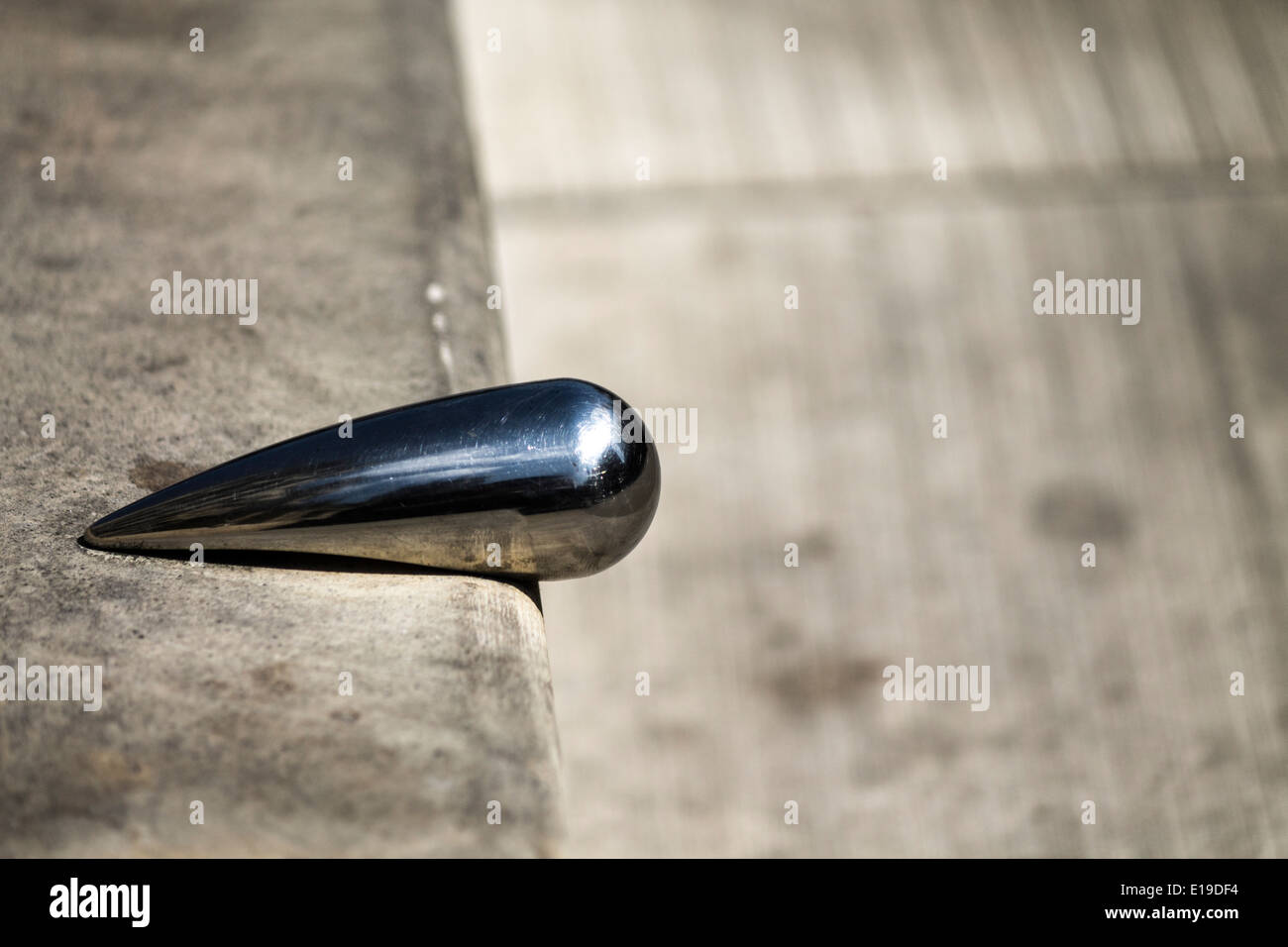 Close up of a small metal blocker on a stone step Stock Photo - Alamy