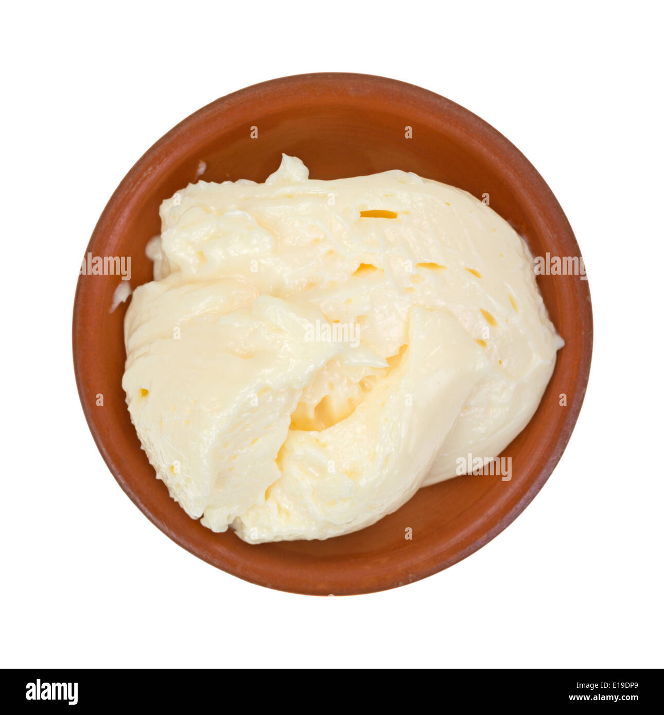 Top view of a small portion of mayonnaise in a small red dish against a ...