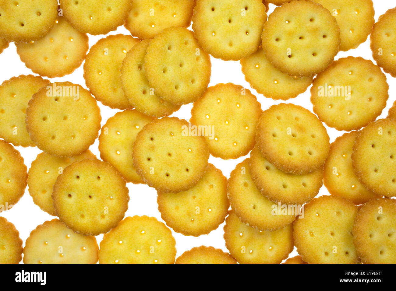 A group of very small round snack crackers atop a white background ...
