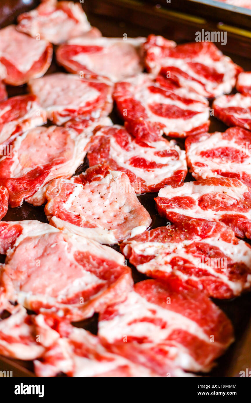 Pieces of fresh raw meat in a frying pan. Cooking meat for roasting ...