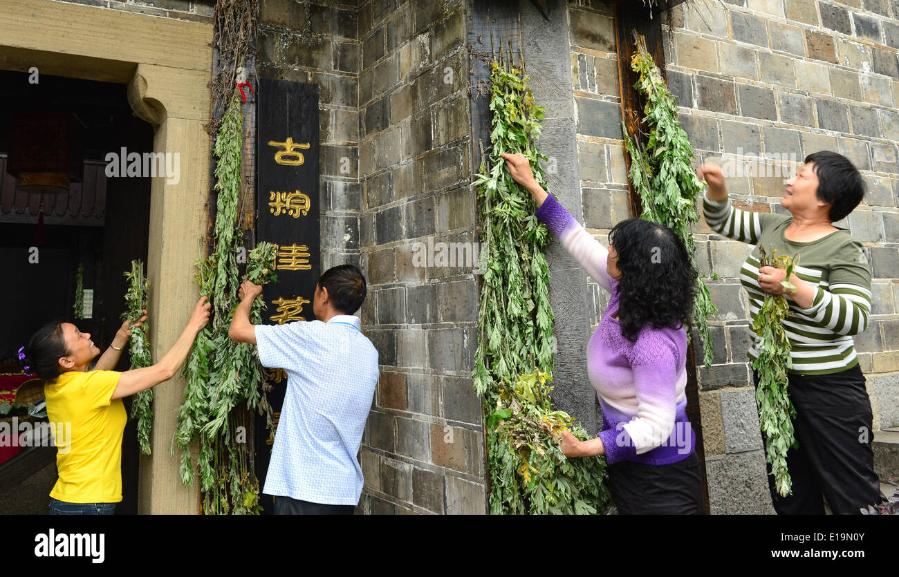 Zigui, Yichang, China . 28th May, 2014. People hang mugwort leaves at ...