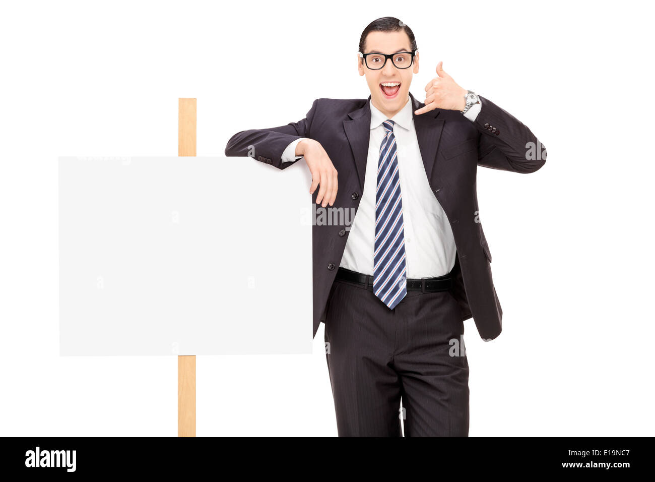 Businessman standing by a banner and making a phone call sign with hand ...