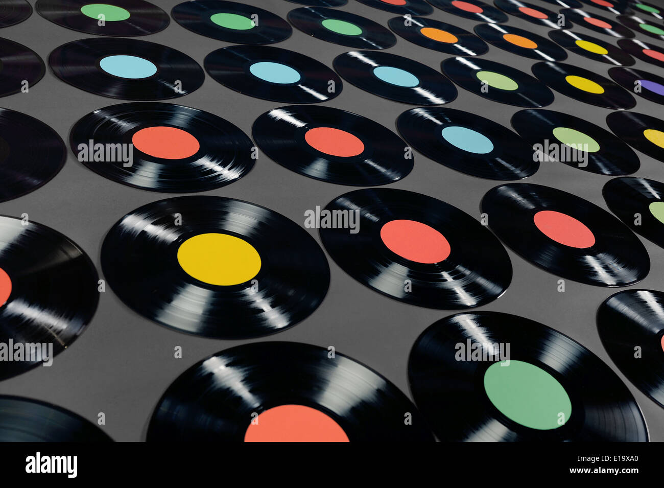 Colorful collection of vinyl records on dark grey background, angle ...