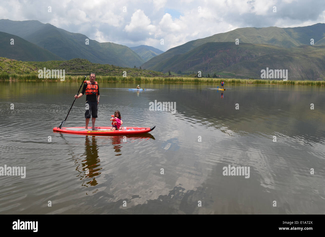 A man Stand Up Paddle Boarding (SUP) with his children on Laguna ...
