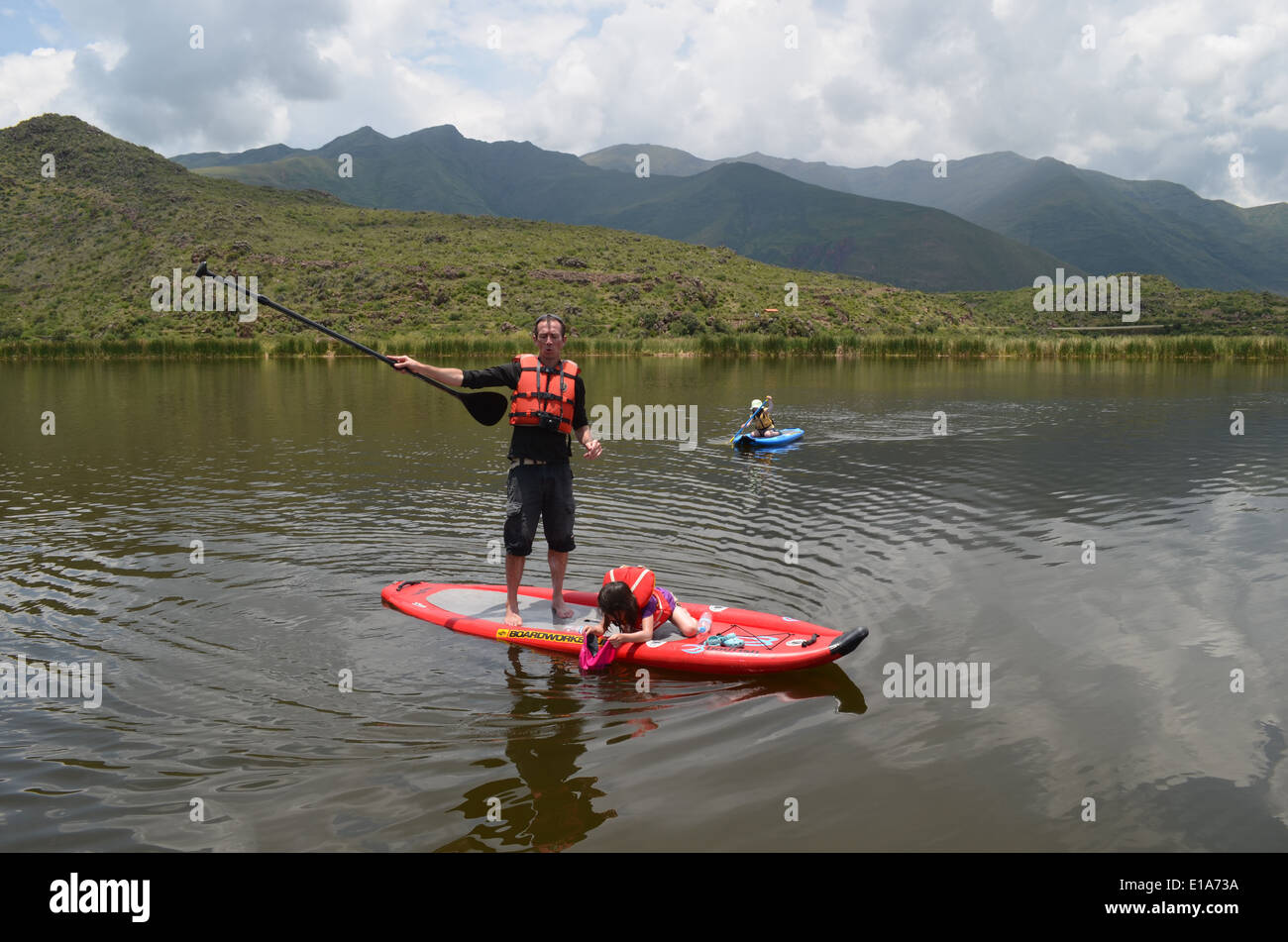 A man Stand Up Paddle Boarding (SUP) with his children on Laguna ...