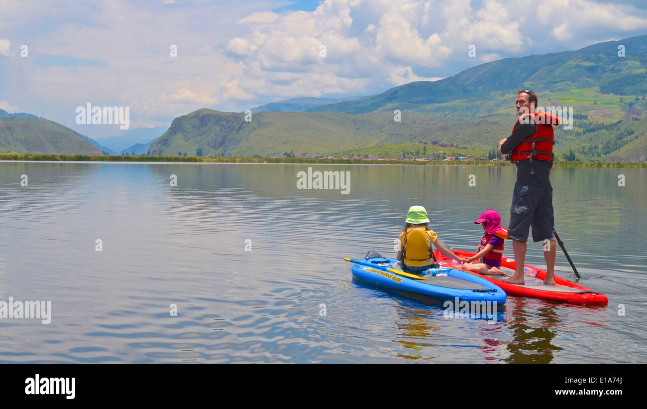 A man Stand Up Paddle Boarding (SUP) with his children on Laguna ...