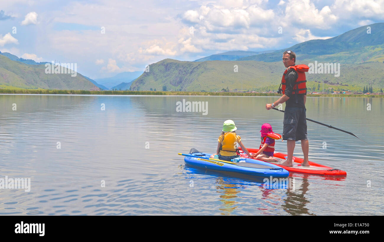 A man Stand Up Paddle Boarding (SUP) with his children on Laguna ...