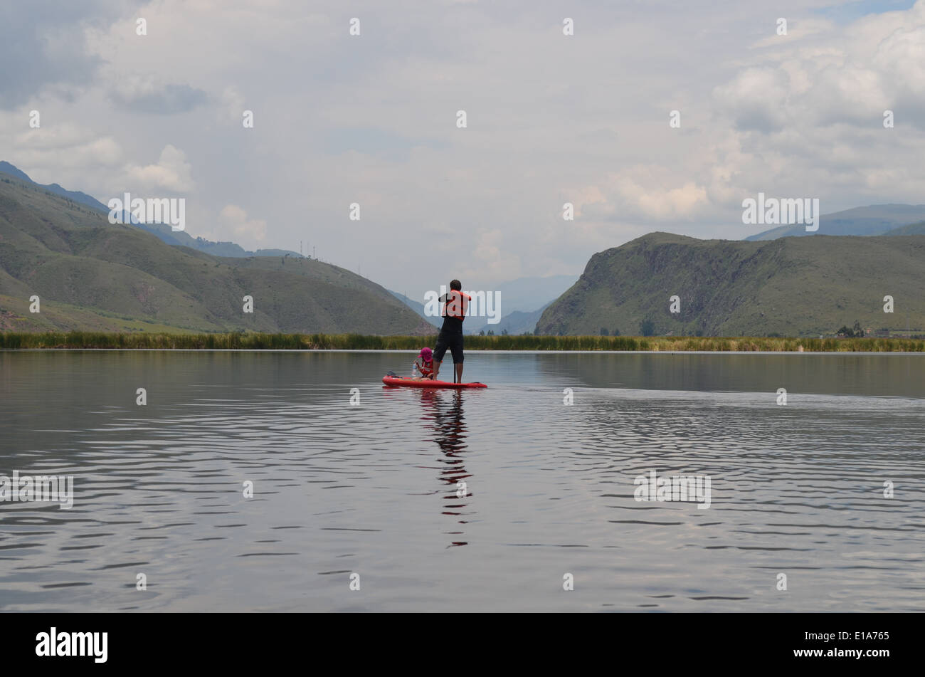 A man Stand Up Paddle Boarding (SUP) with his children on Laguna ...