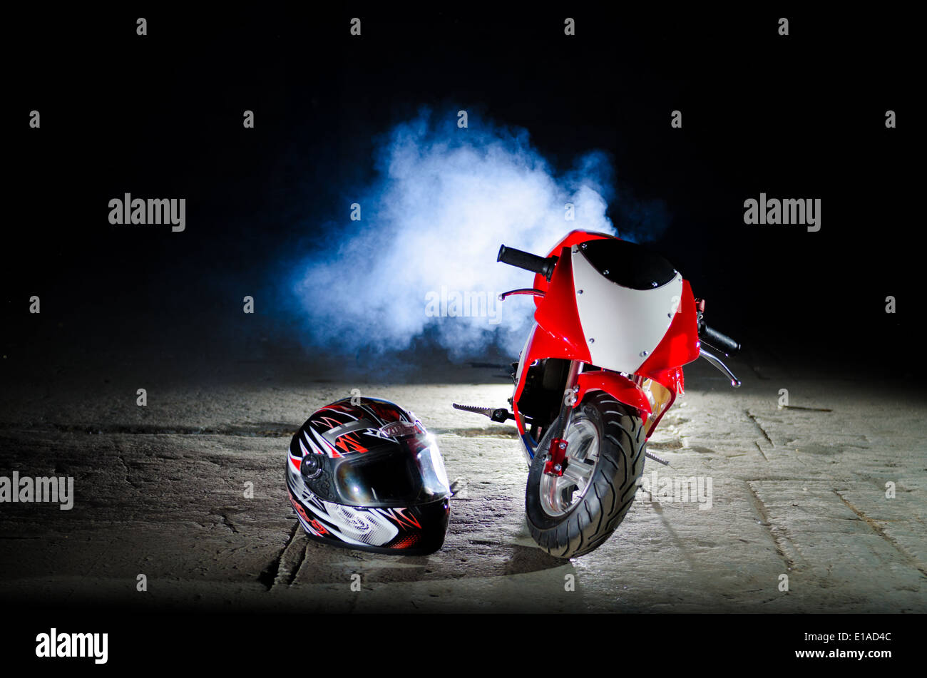 Photograph of a mini moto in a disused warehouse with a black ...